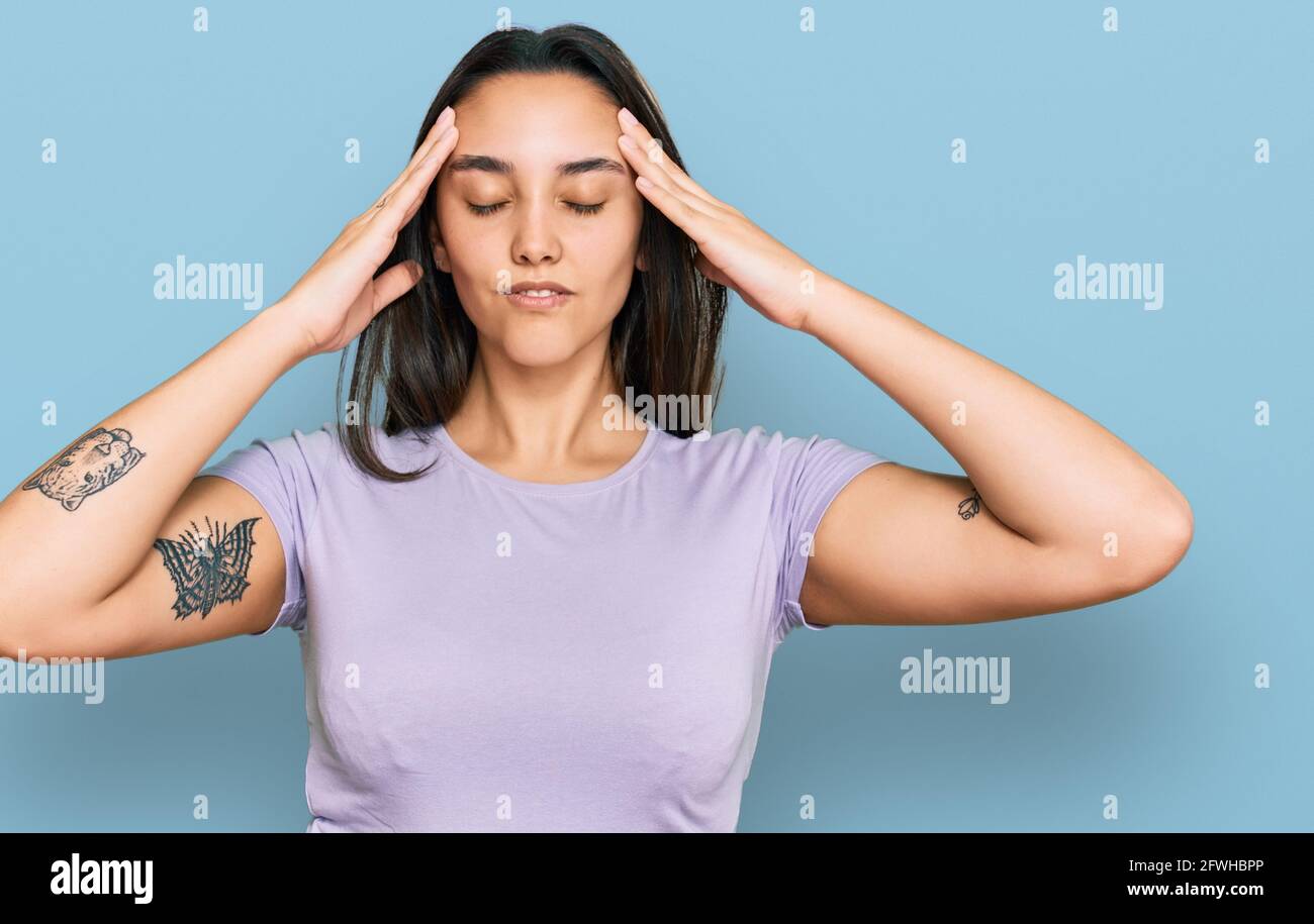 Young hispanic woman wearing casual clothes suffering from headache ...