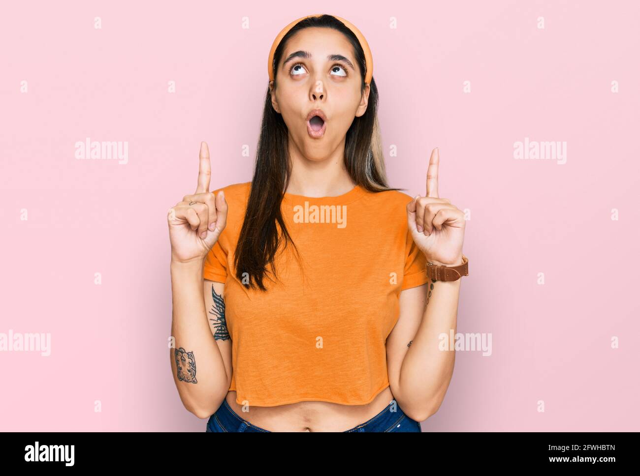 Young hispanic woman wearing casual clothes amazed and surprised ...