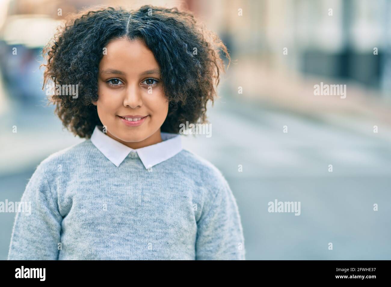 Adorable hispanic child girl smiling happy standing at the city Stock ...