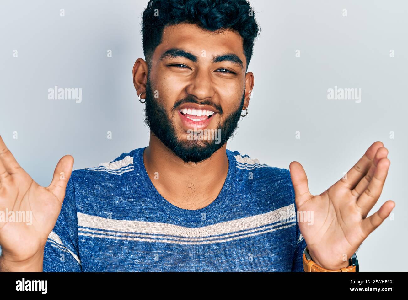 Arab man with beard wearing casual striped t shirt celebrating victory ...