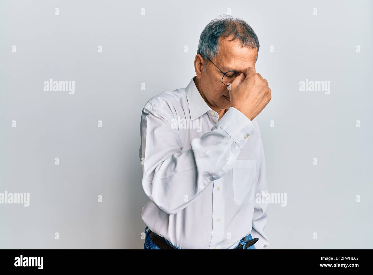 Middle age indian man wearing casual clothes and glasses tired rubbing ...