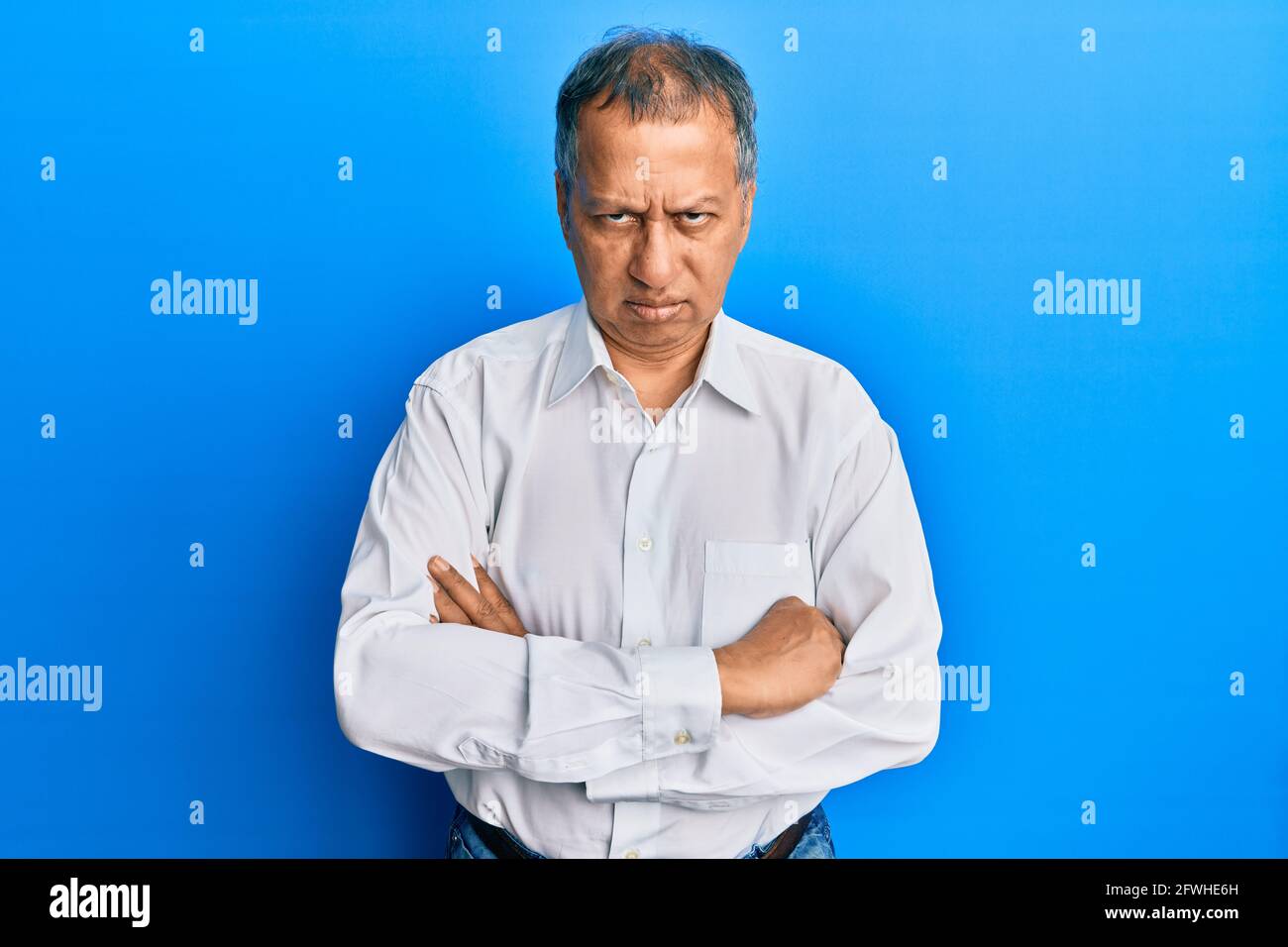 Middle age indian man with arms crossed gesture skeptic and nervous ...