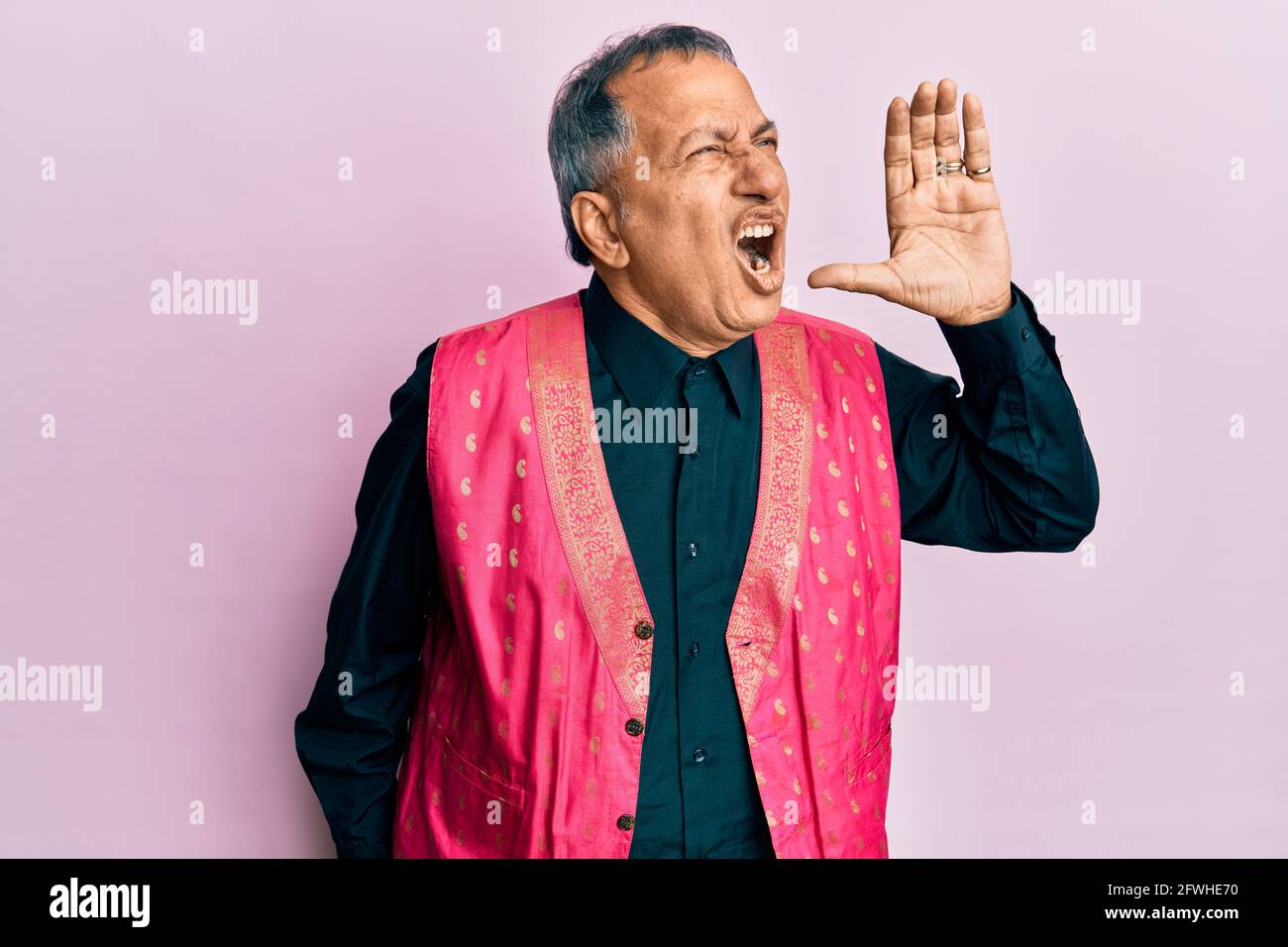 Middle age indian man wearing traditional indian clothes shouting and ...