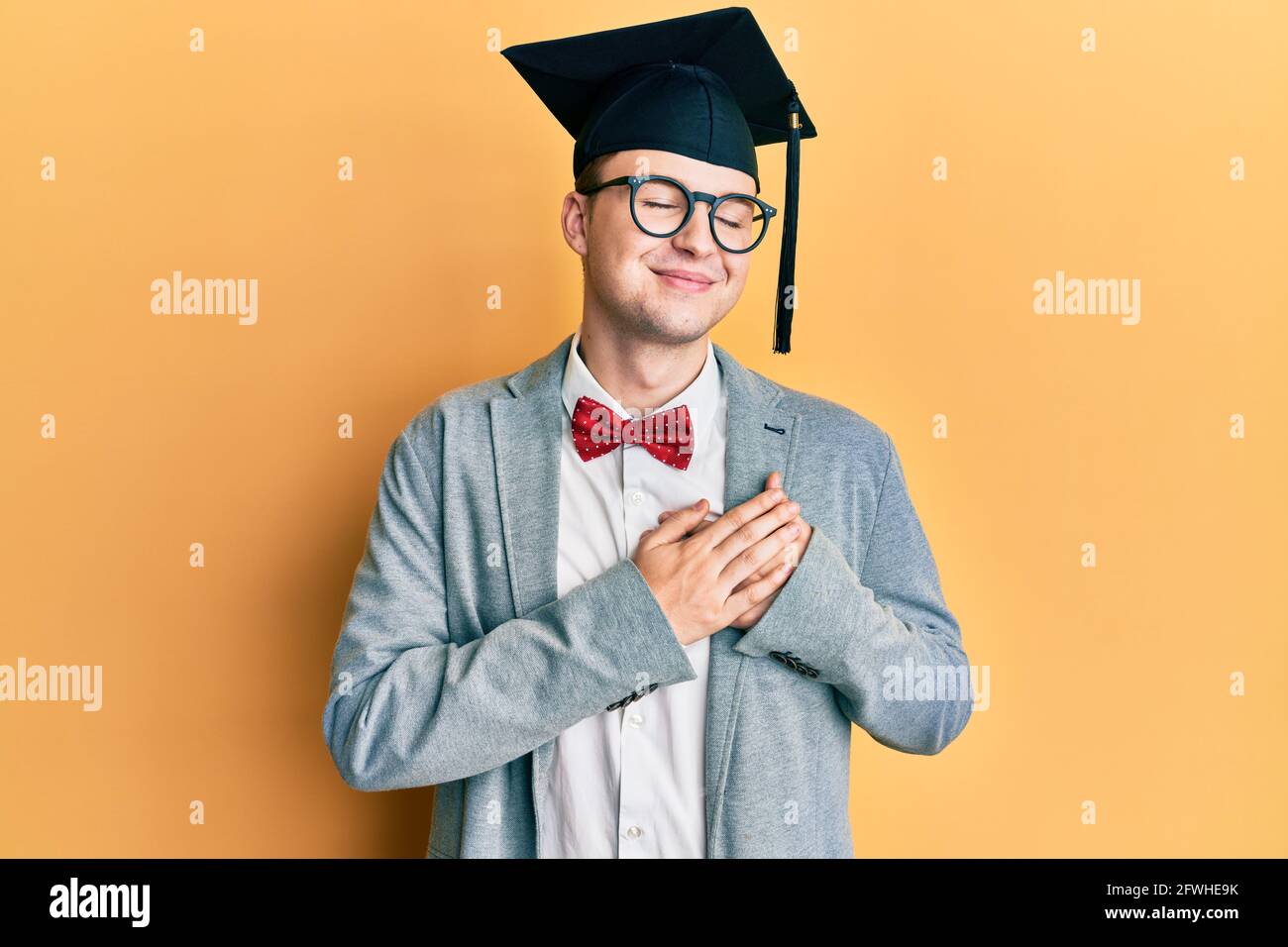 Young caucasian nerd man wearing glasses and graduation cap smiling ...
