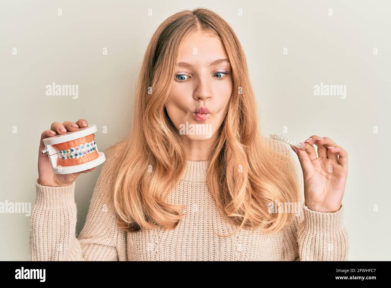 Beautiful young caucasian girl holding invisible aligner orthodontic ...