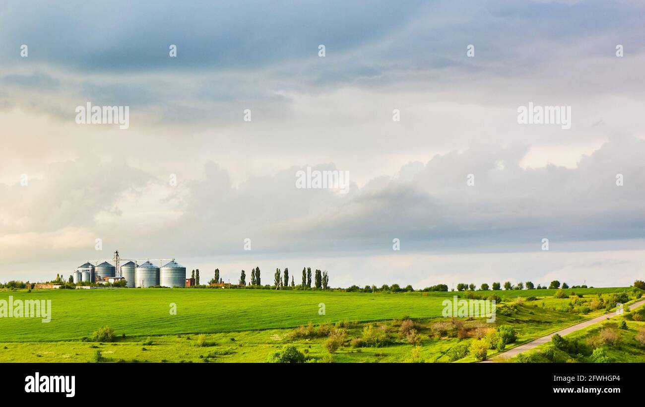 Farm silos at a distant farm at sunset Stock Photo - Alamy