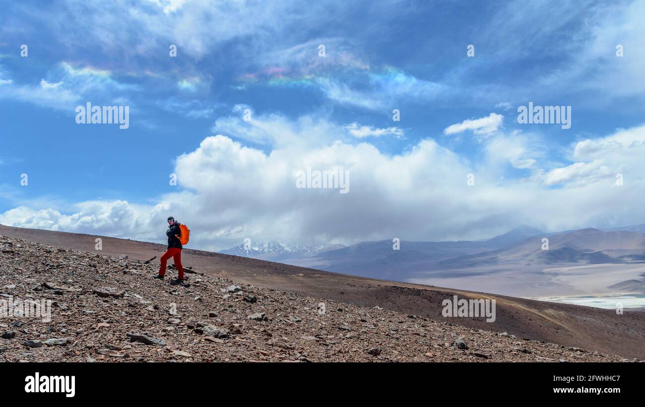 Young man climbing volcano Siete Hermanos in the heart of the Atacama ...