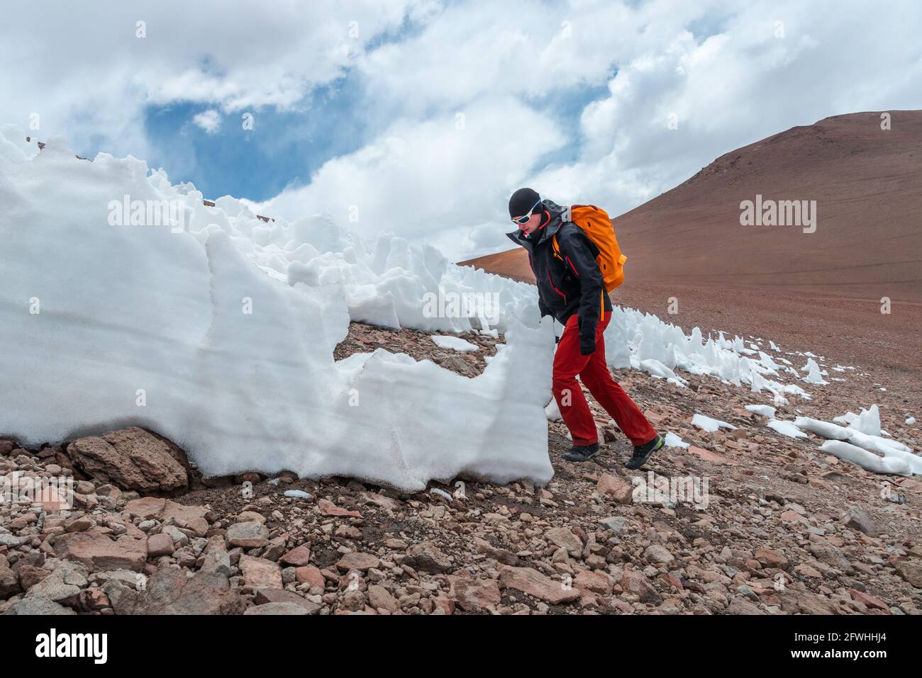 Person on the dry arid climate of high-altitude desert in front of huge ...