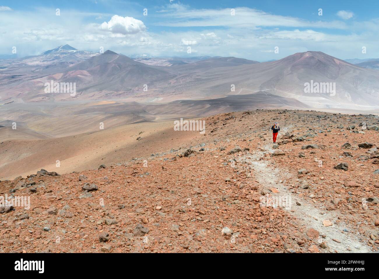 Climber ascending Siete Hermanos volcano above Laguna Santa Rosa in ...