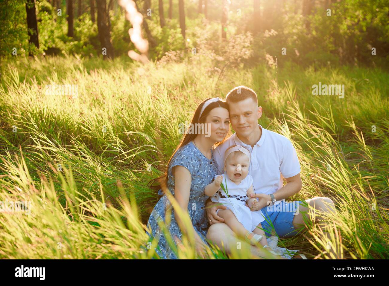 Happy family dad, mom playing in the fresh air on the field watching ...