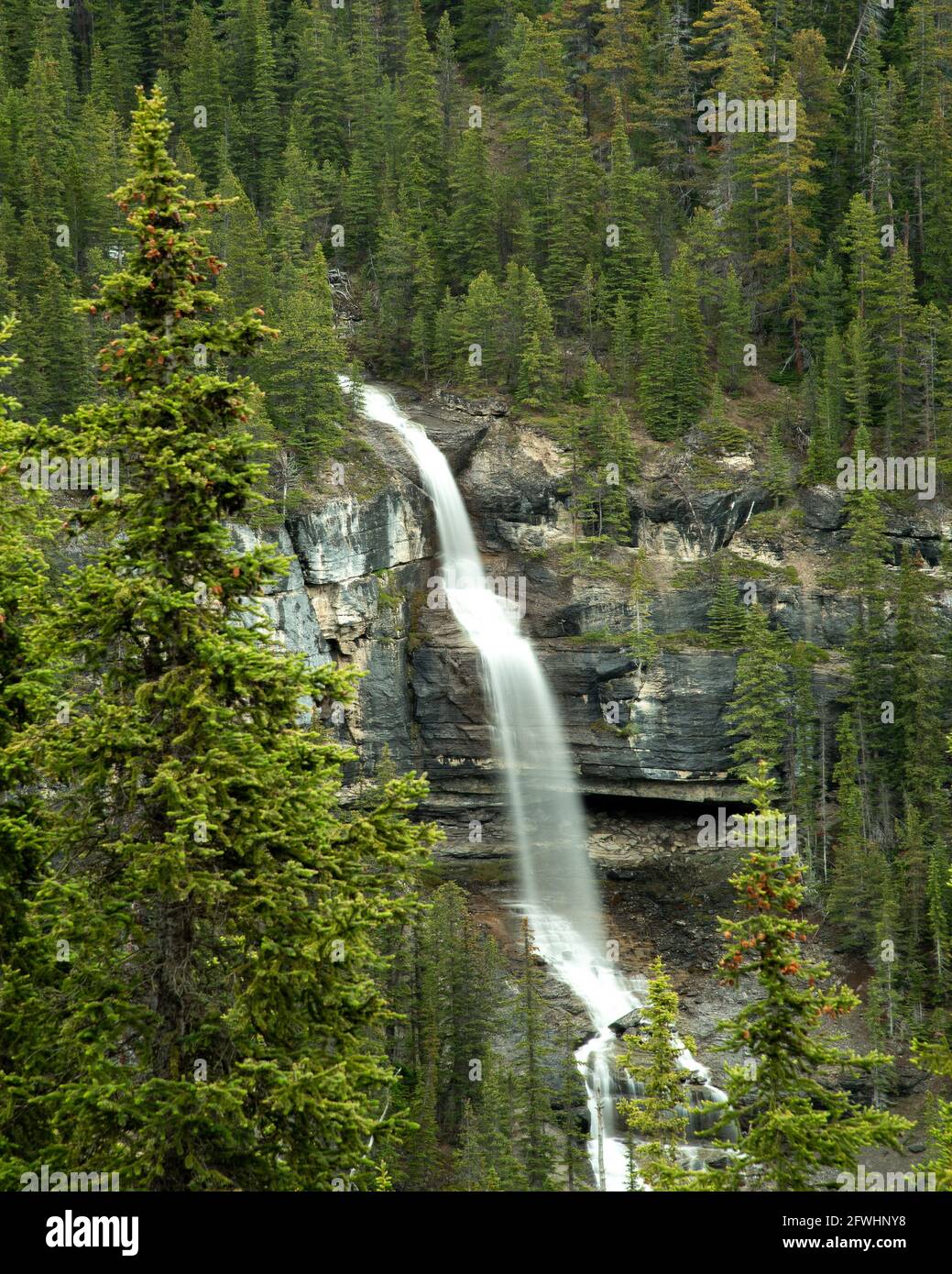 Waterfall tumbling down the side of a rock cliff face in Alberta ...
