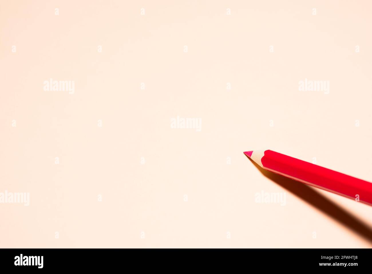 One red pencil on a light orange background with a dark shadow Stock ...
