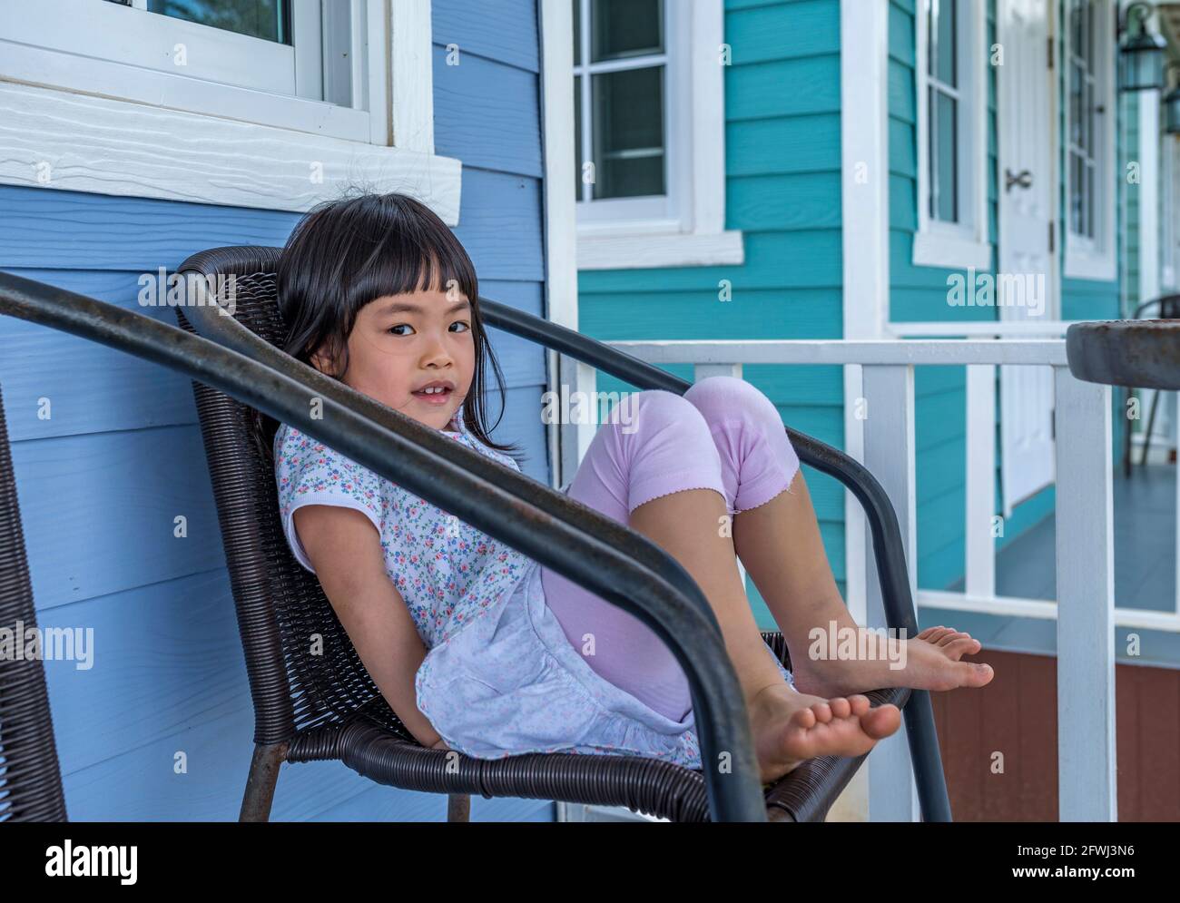 Portrait beautiful Asian little girl sitting on a chair in front of the ...
