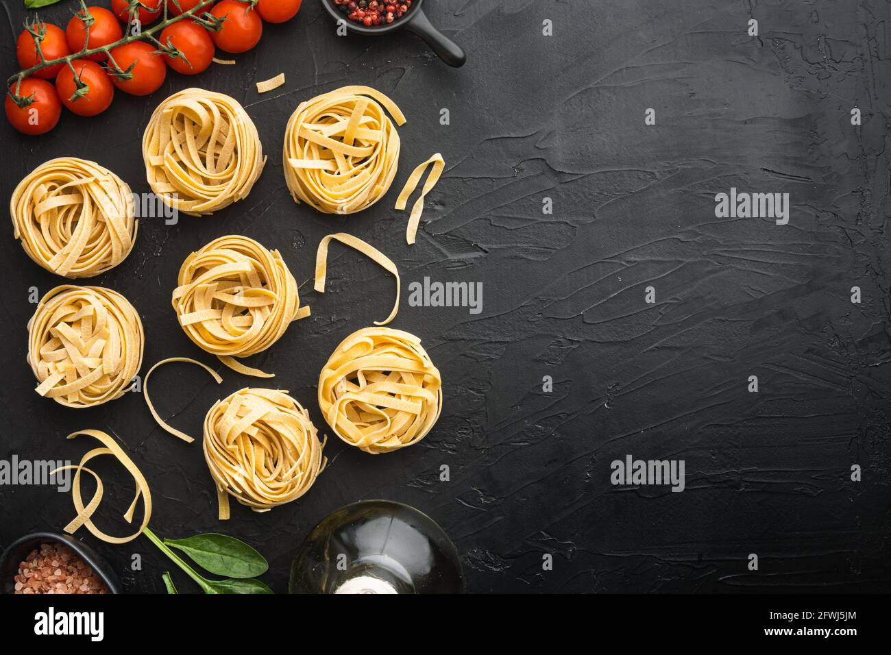 Rolled tagliatelle shape of italian pasta with ingredients set, on ...