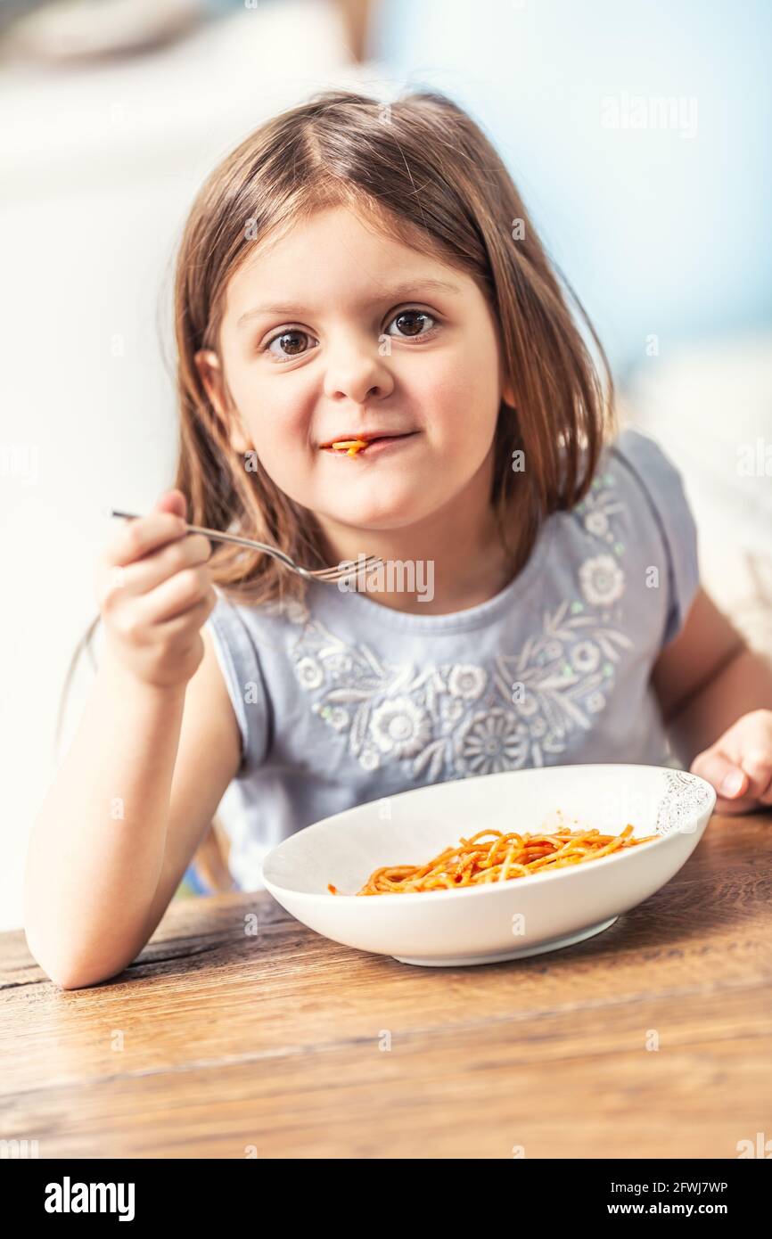 Little girl at home in the kitchen tasting Italian spaghetti Stock ...