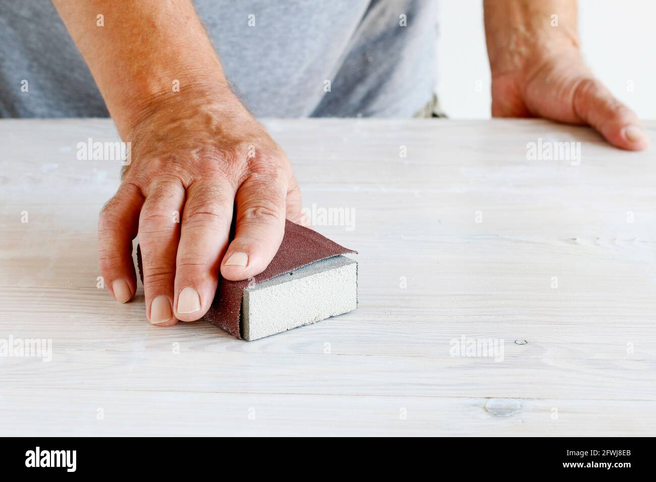 Man uses a sandpaper to restore wooden surface. Hobby time Stock Photo ...