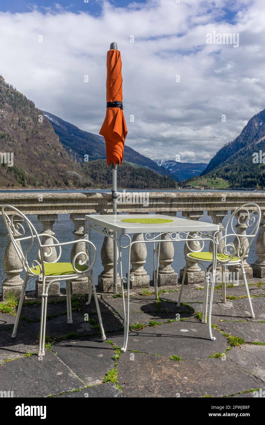 A closed sun shield waits for guests on an empty terrace on the lake of ...