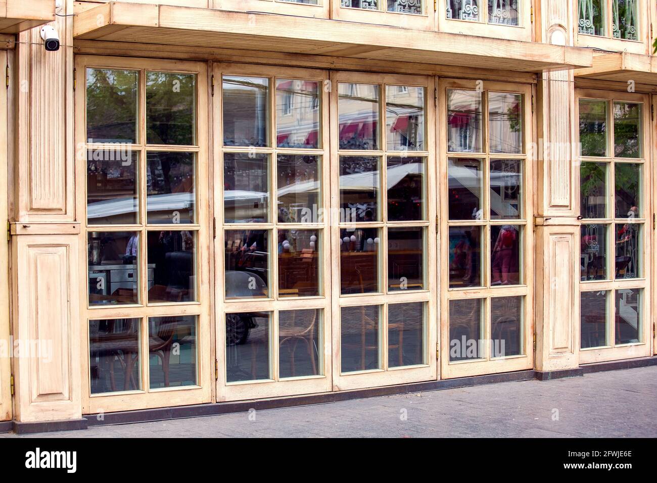 the facade of the restaurant with panoramic beige wooden windows and ...