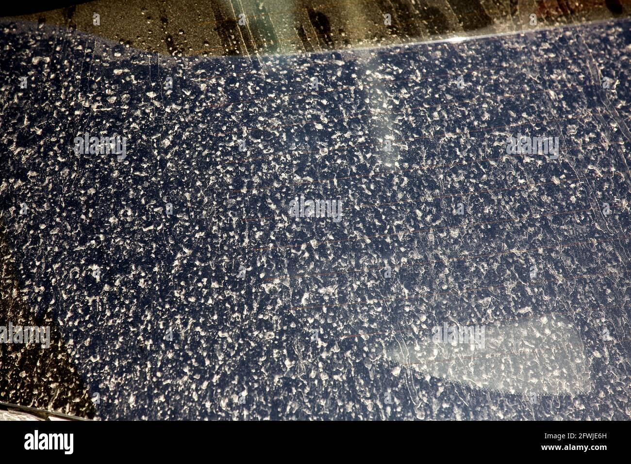 rear window of a dirty car covered with a layer of dry dust in spots ...