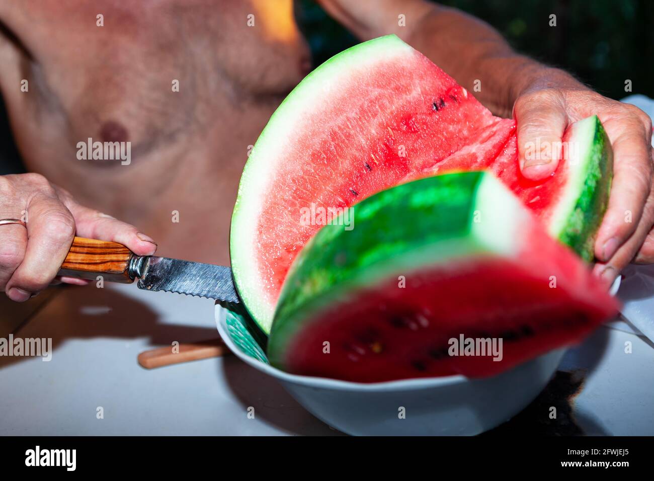 Cutting a watermelon with a knife . Farmer cuts slices of watermelon ...