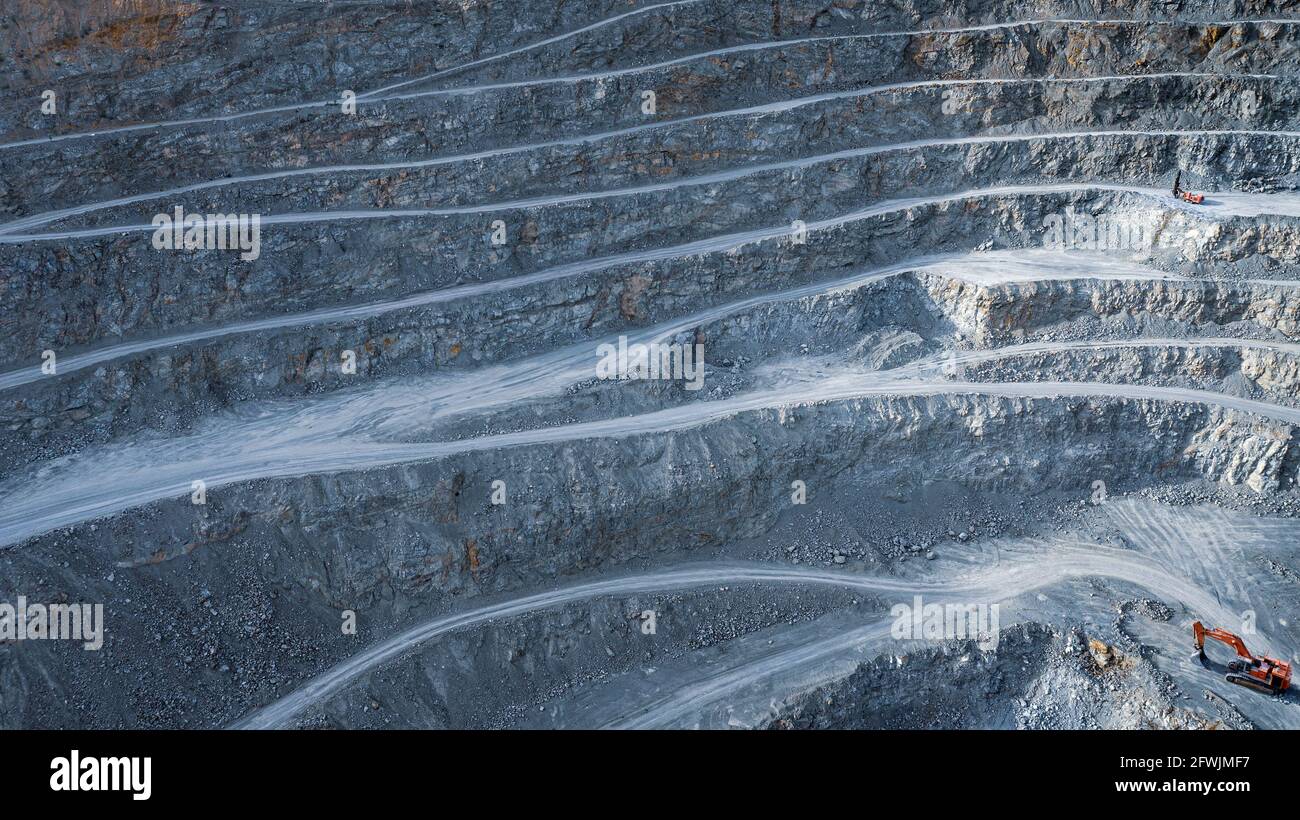Striped pattern of terraces in open pit stone quarry, industrial ...