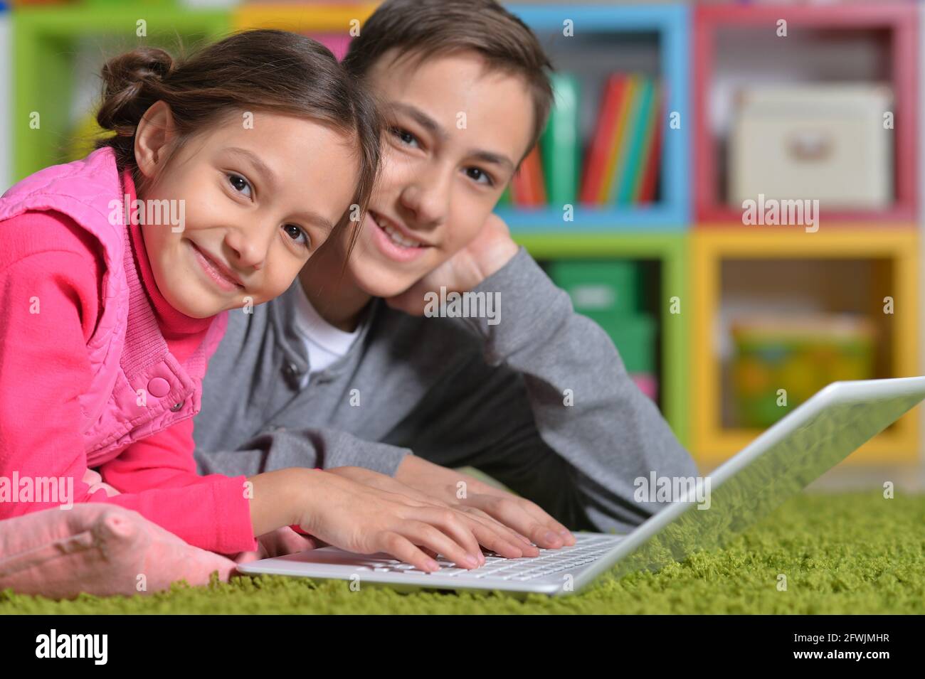 Happy brother and sister using modern laptop Stock Photo - Alamy