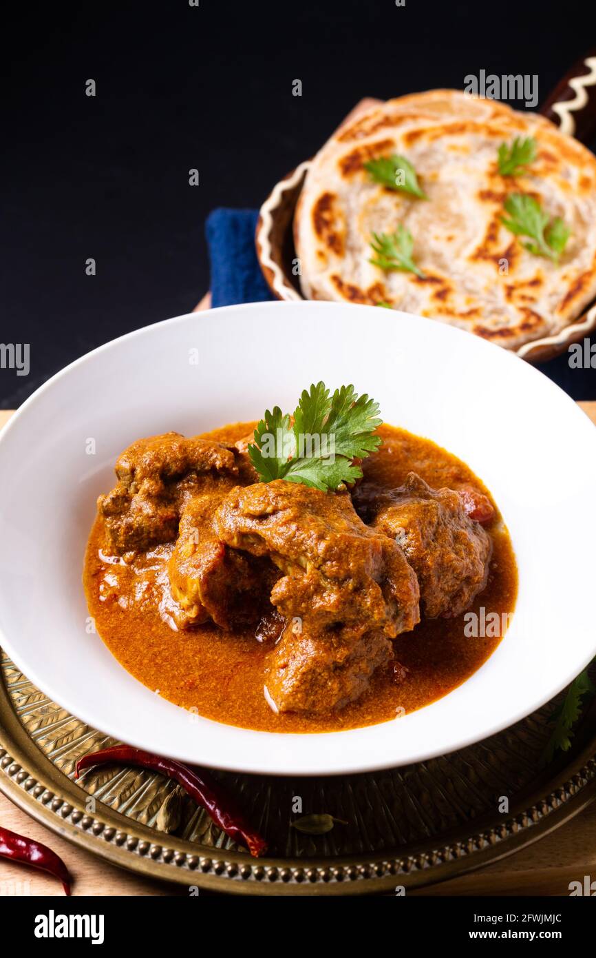 Food concept Homemade beef masala curry and roti paratha on wooden ...