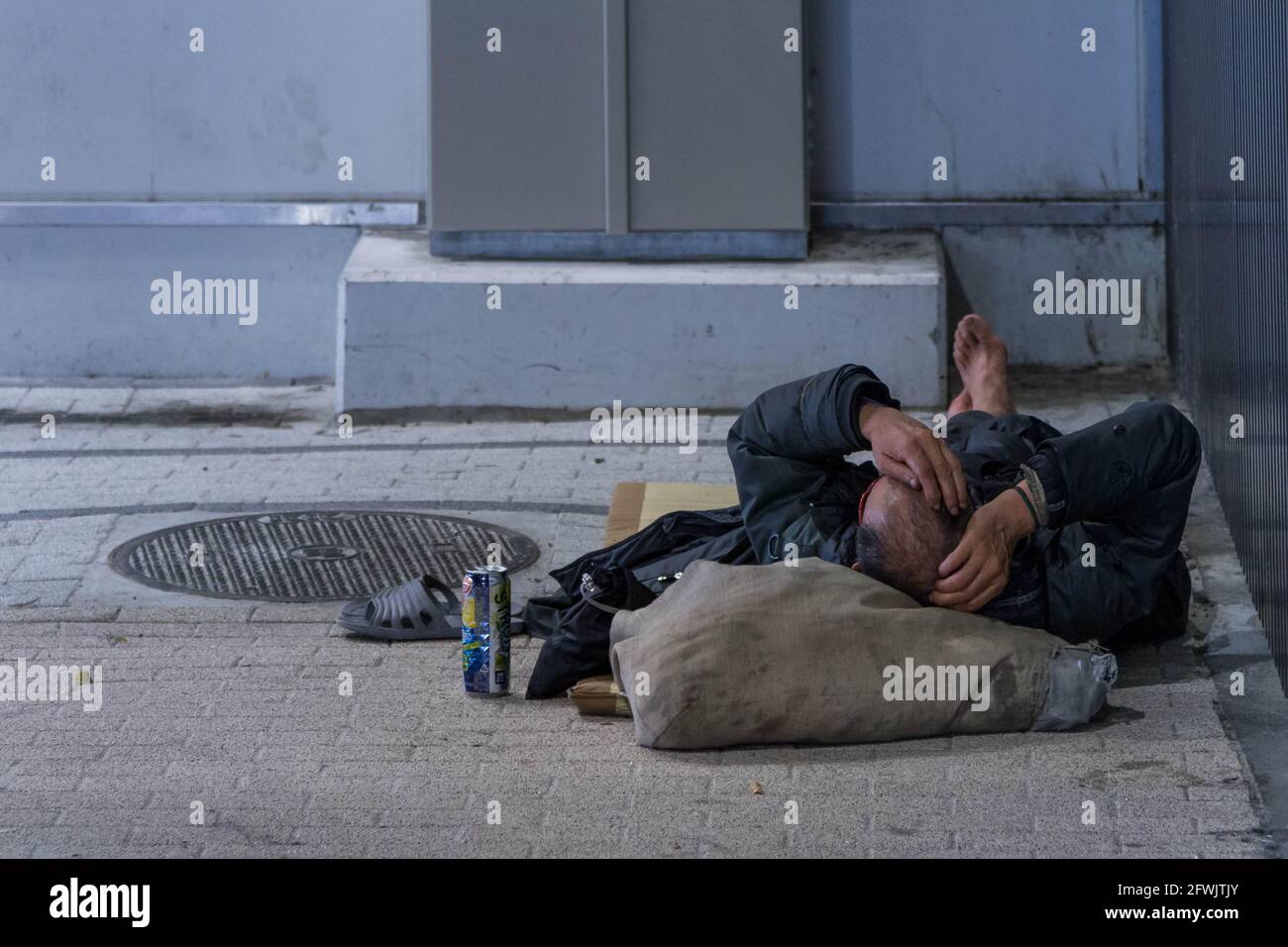 A homeless man sleeping on the street in Southern Shinjuku Stock Photo ...