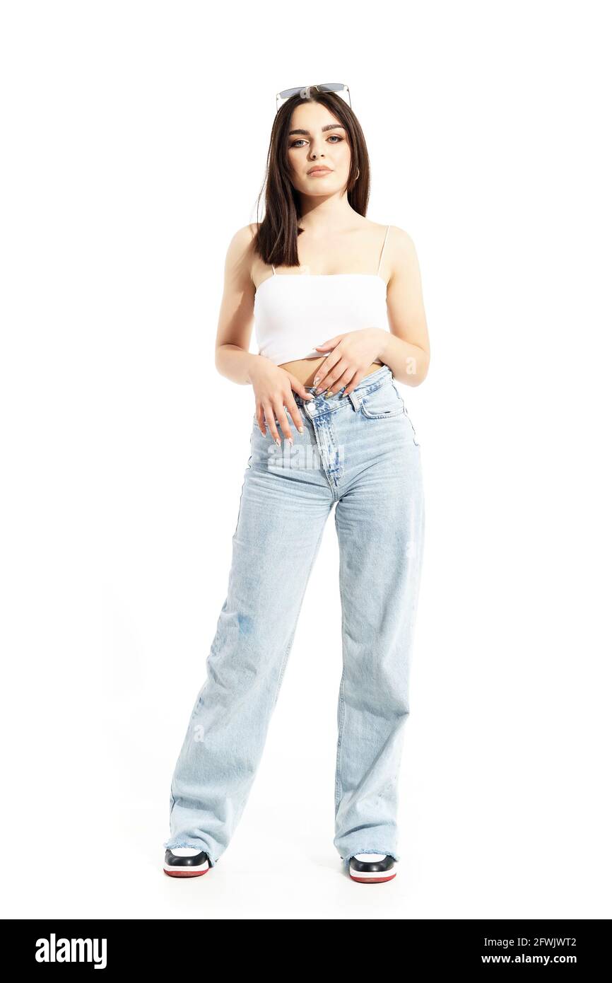 Cute feminine trendy gen Z girl posing relaxed with hands touching ...