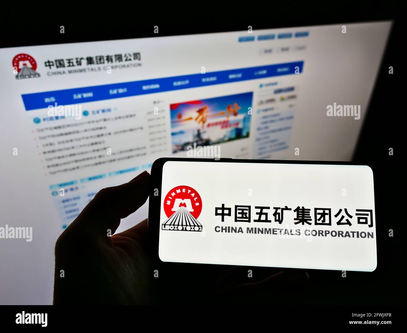 Person holding cellphone with logo of Chinese trading company China ...