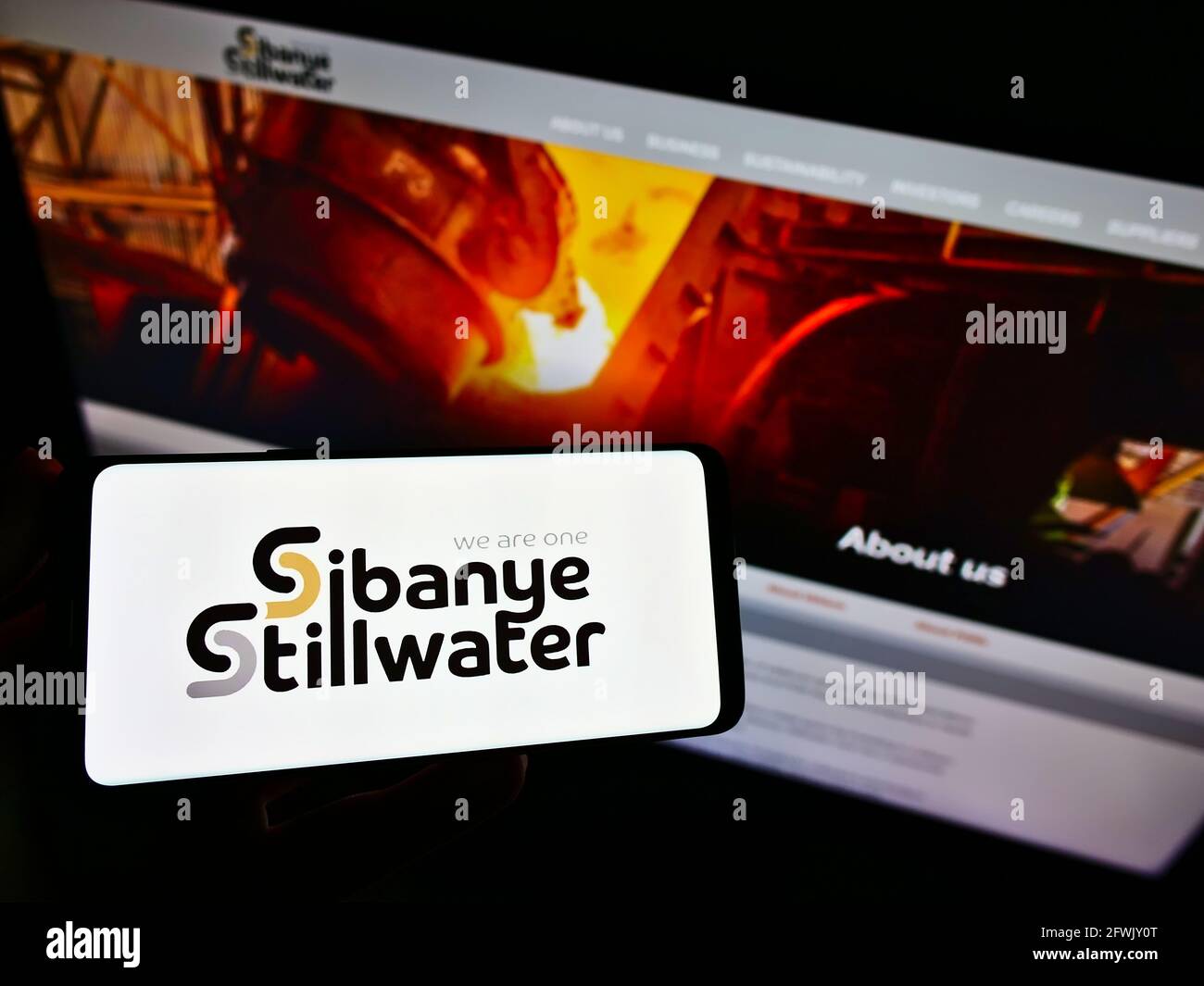 Person holding cellphone with logo of South African mining company ...