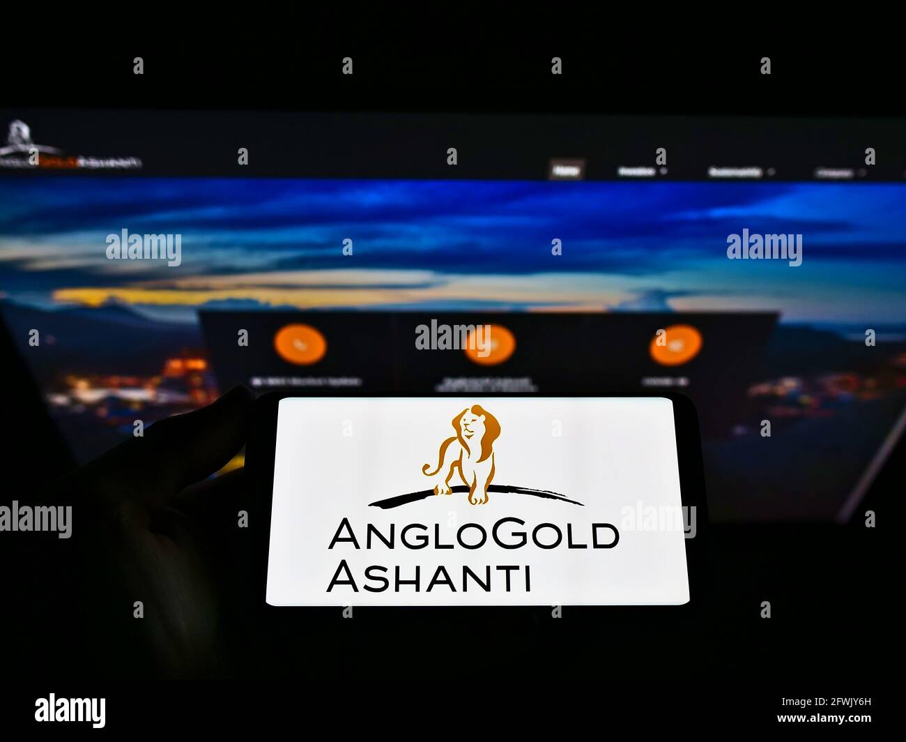 Person holding mobile phone with logo of African mining company ...