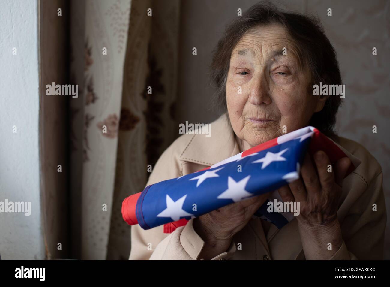 Senior woman with American flag sitting at home Stock Photo - Alamy