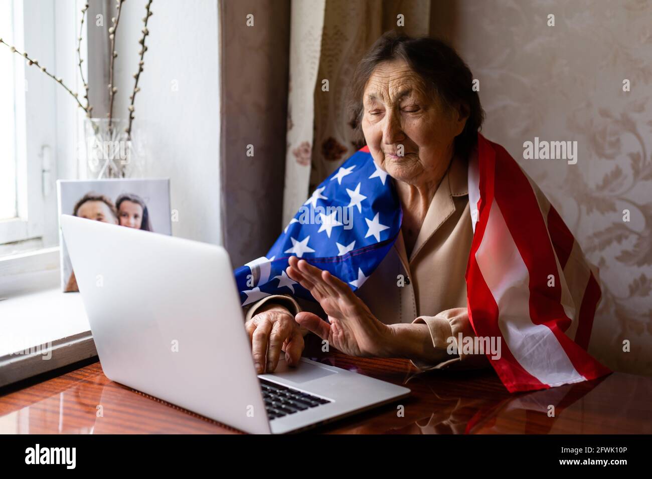 Independence Day celebration after quarantine. Granny looking at laptop ...