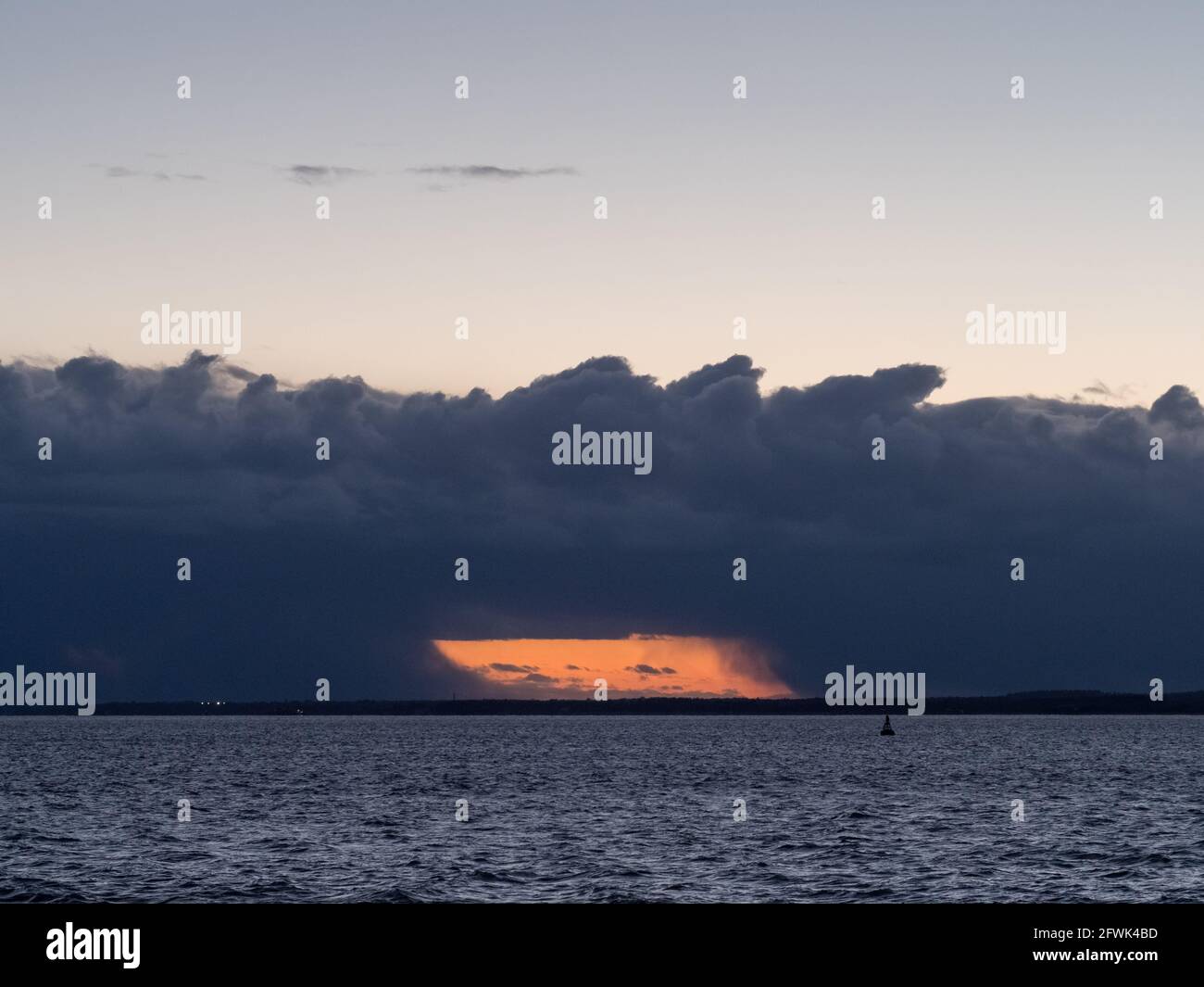 A bright orange weather gap appearing as a window through ominous ...