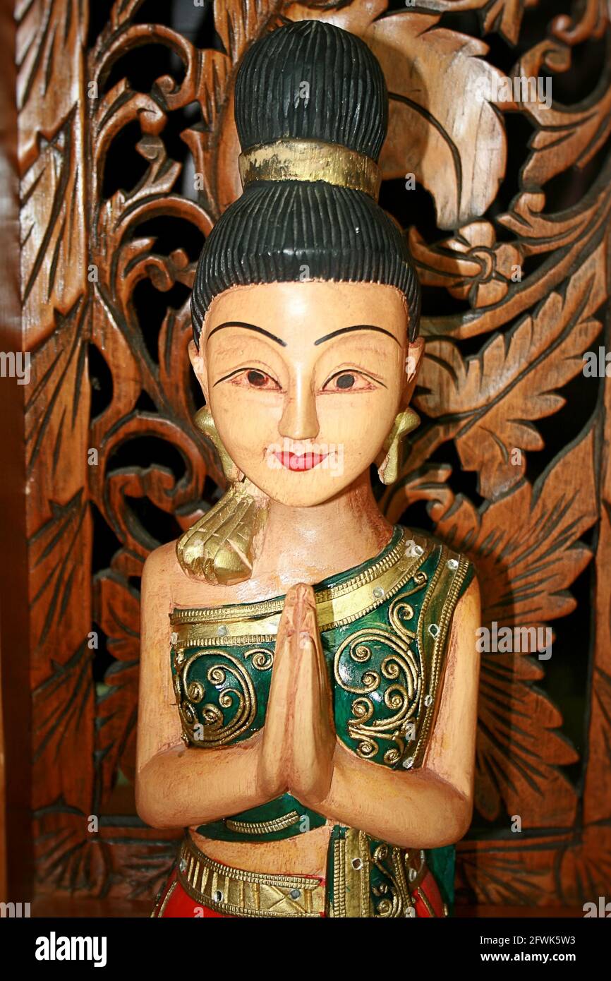 Buddhist statue of a girl on a wood background Stock Photo - Alamy