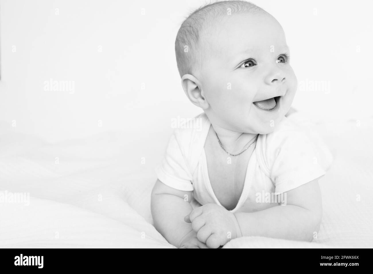 Portrait of beautiful baby girl laying on comfortable bed at home ...