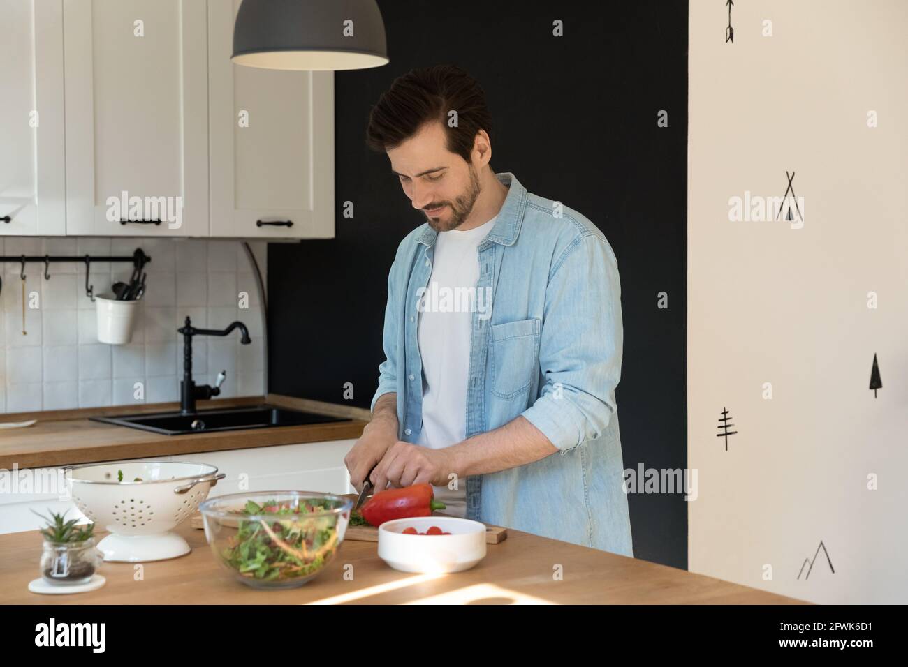 Handsome happy young man cooking alone in kitchen Stock Photo - Alamy
