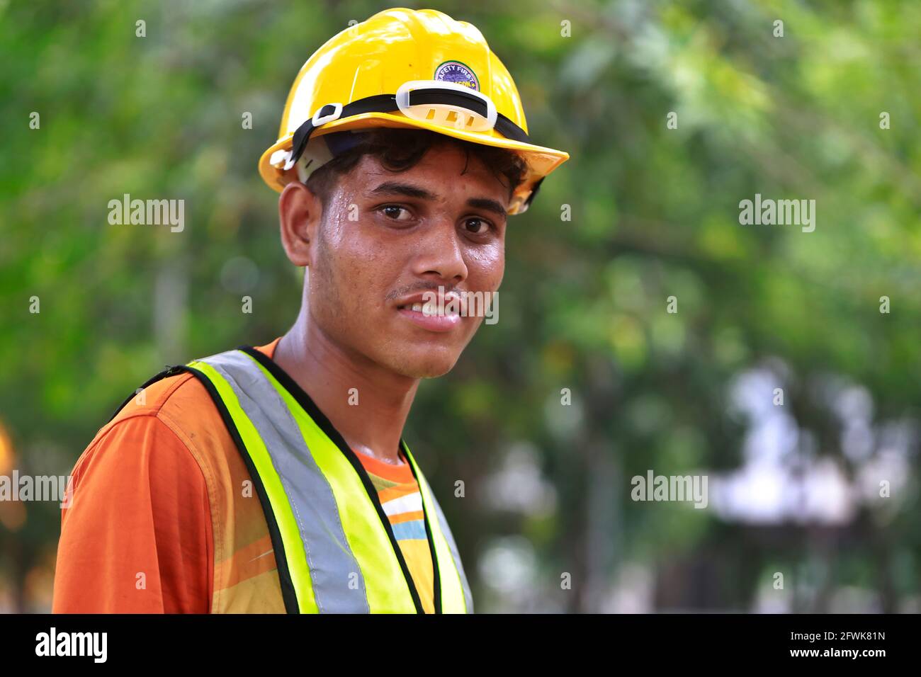 Dhaka, Bangladesh - May 23, 2021: Construction workers sit under a tree ...
