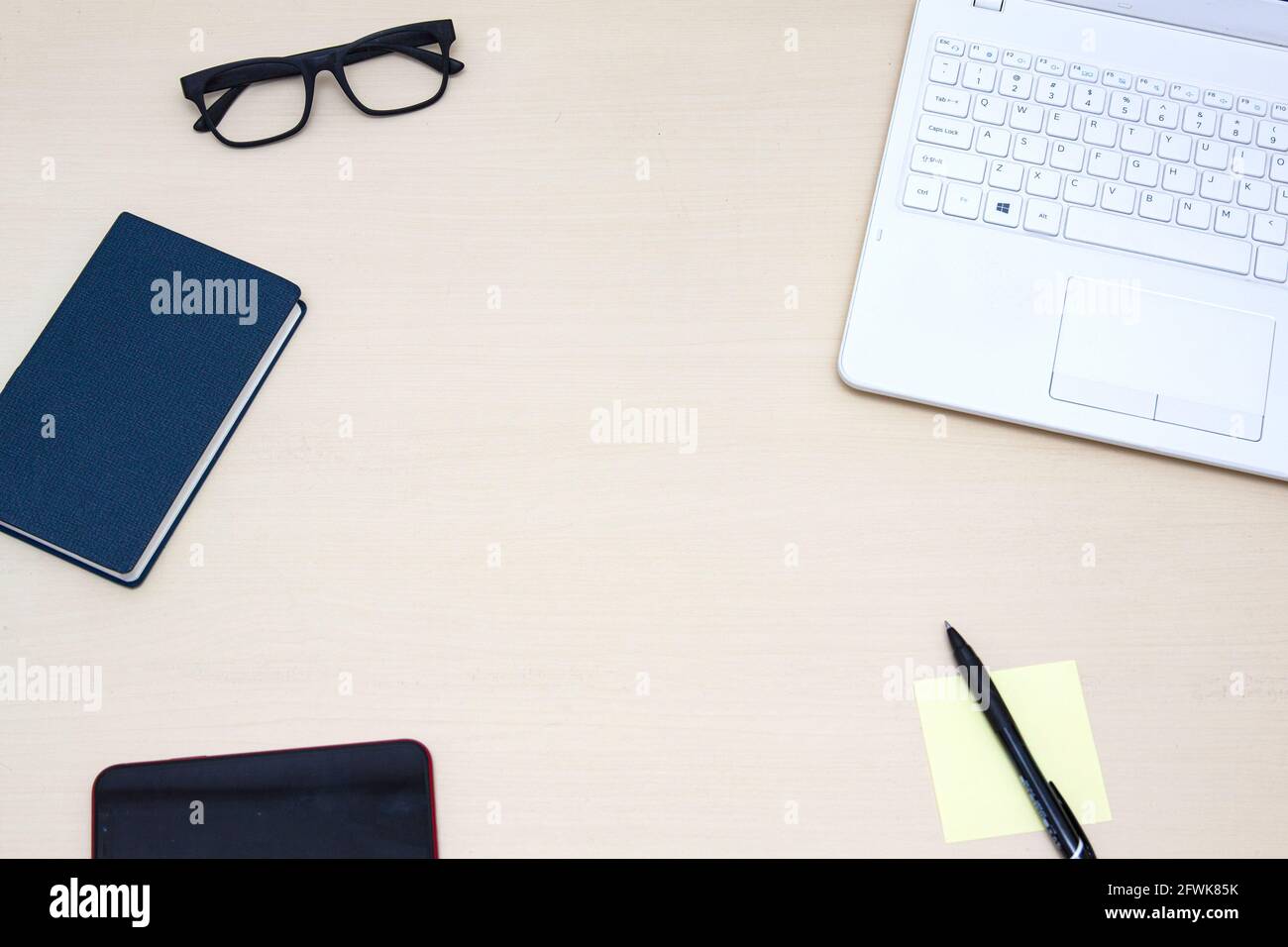 Stylish office desk with laptop, diary and workspace on white ...