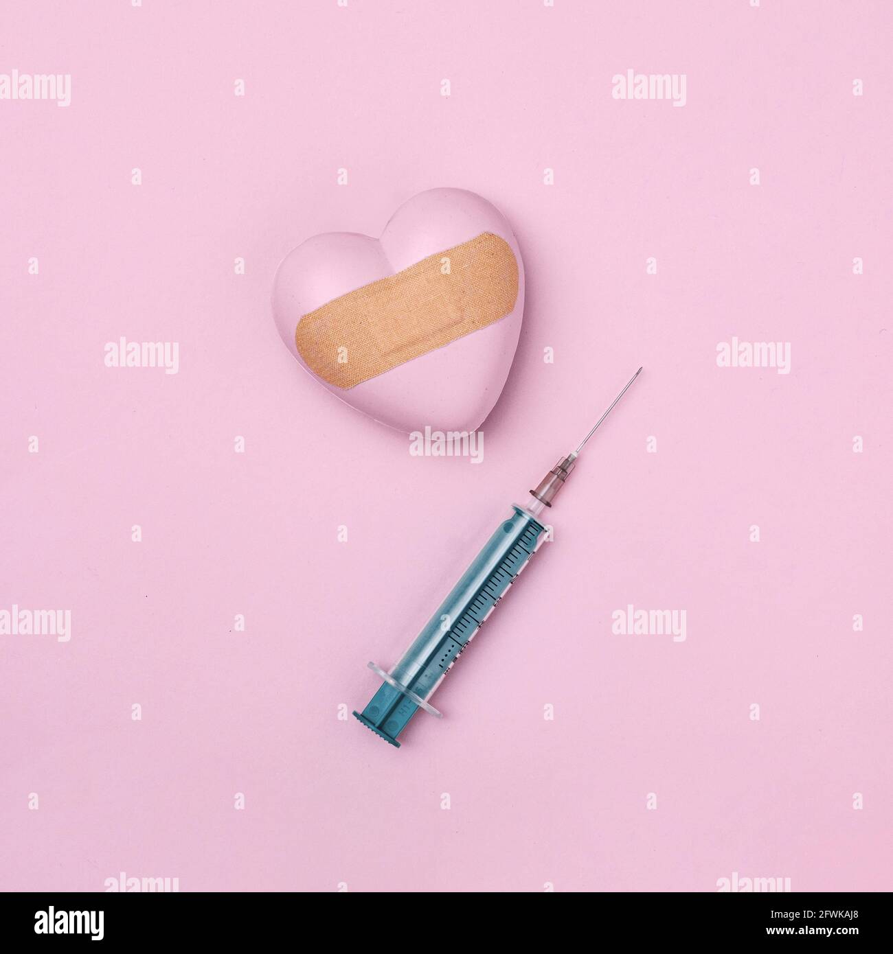 Heart sealed with medical plaster and a syringe for vaccination or ...