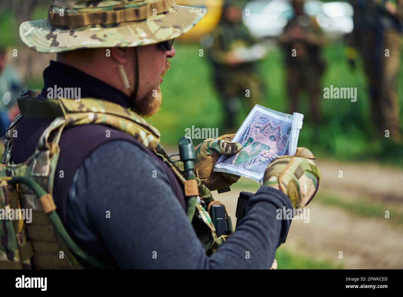 Airsoft player in military uniform examining a map Stock Photo - Alamy