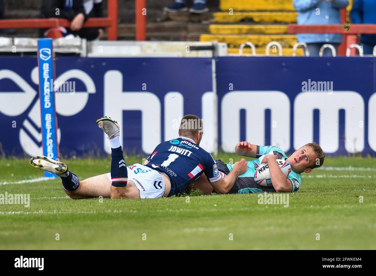 Jez Litten (14) of Hull KR is tackled by Max Jowitt (1) of Wakefield ...