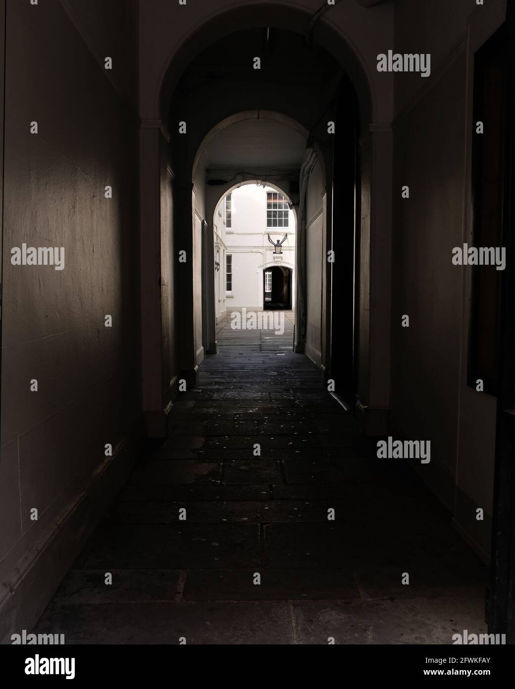 May 2021 - Long dark passageway through to a courtyard in the city of ...