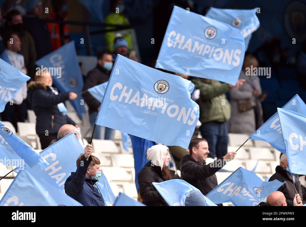 Manchester city fans wave flags in the stands hi-res stock photography ...