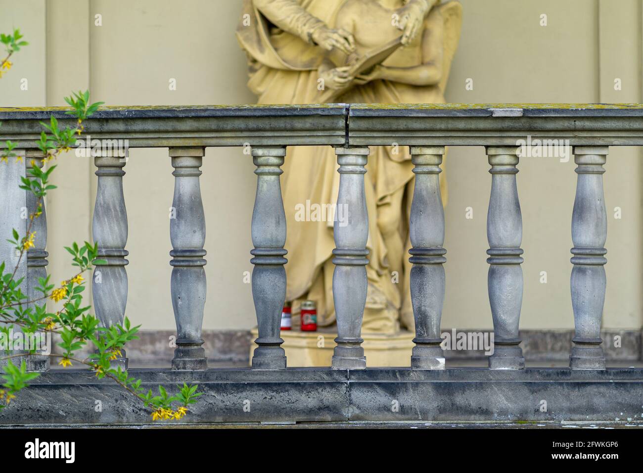 A stone railing in front of a statue of a wise old man and a child ...