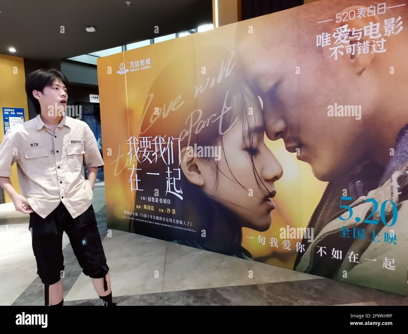 YICHANG, CHINA - MAY 22, 2021 - Citizens walk past movie posters at Wanda Cinemas in Yichang ...
