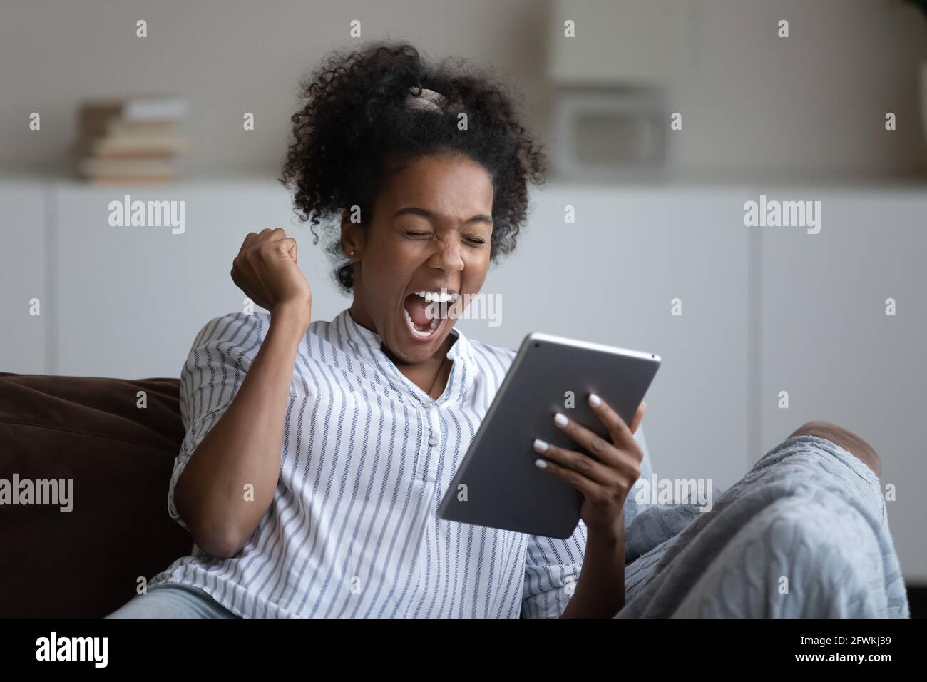 Sincere young multiracial lady feeling overjoyed, celebrating online ...