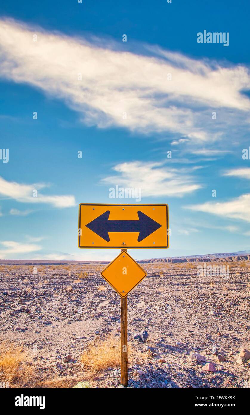 Directional sign in the desert with scenic blue sky and wide horizon ...