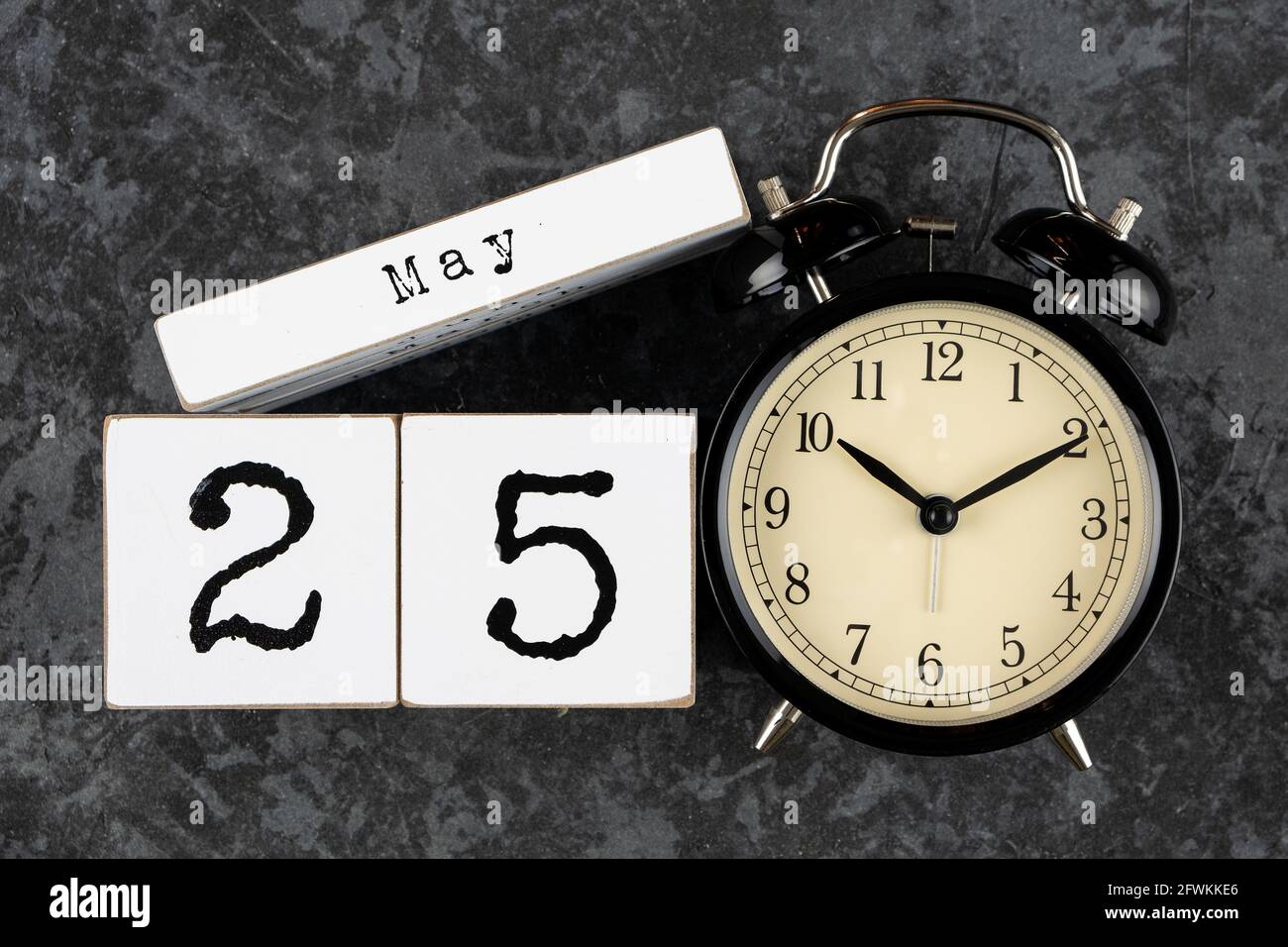 May 25th. May 25 white wooden cube calendar and alarm clock on grey ...